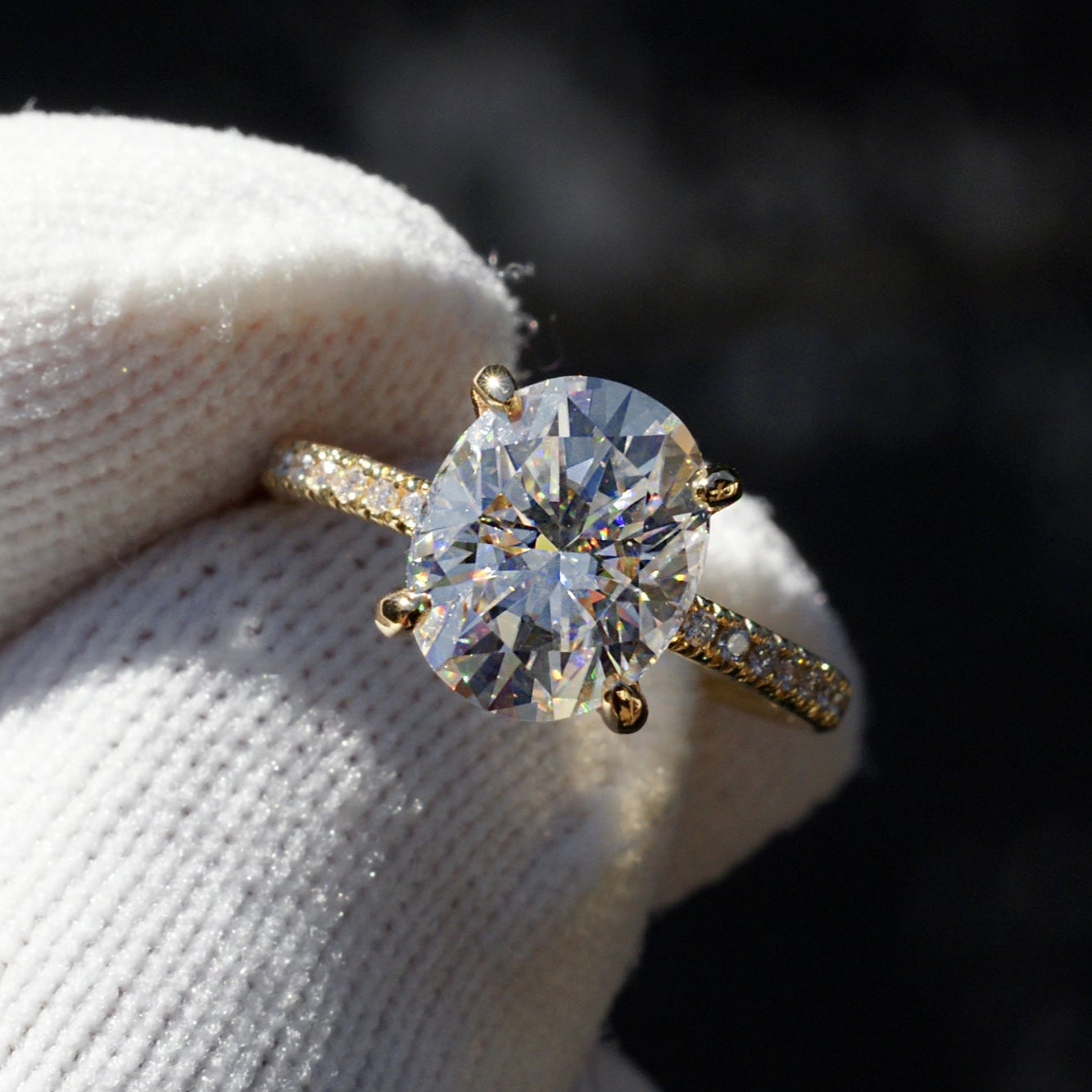 Oval moissanite engagement ring with pave diamond band and hidden halo
